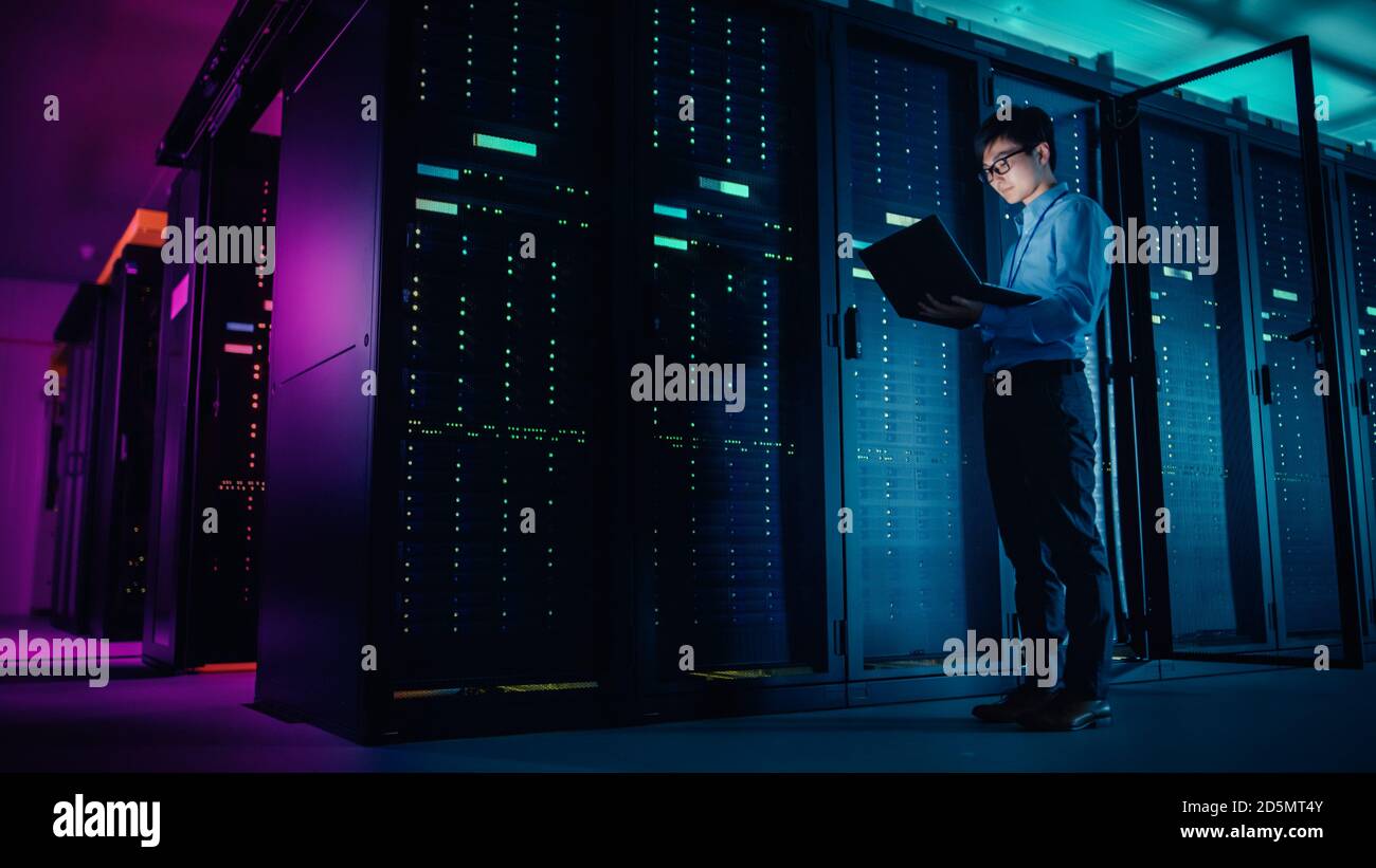 In Data Center: Male IT Technician Running Maintenance Programme on a ...