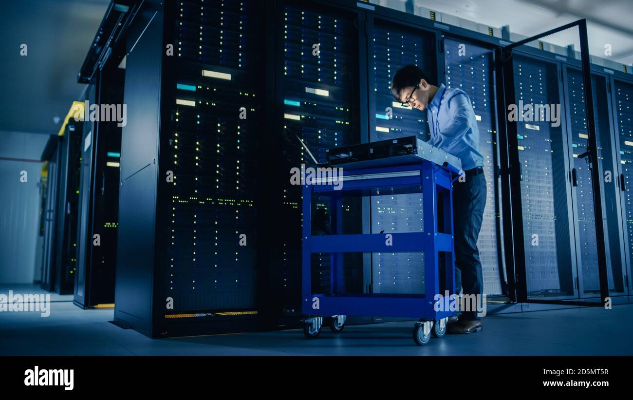 In Data Center: Male IT Technician Running Maintenance Programme on a ...