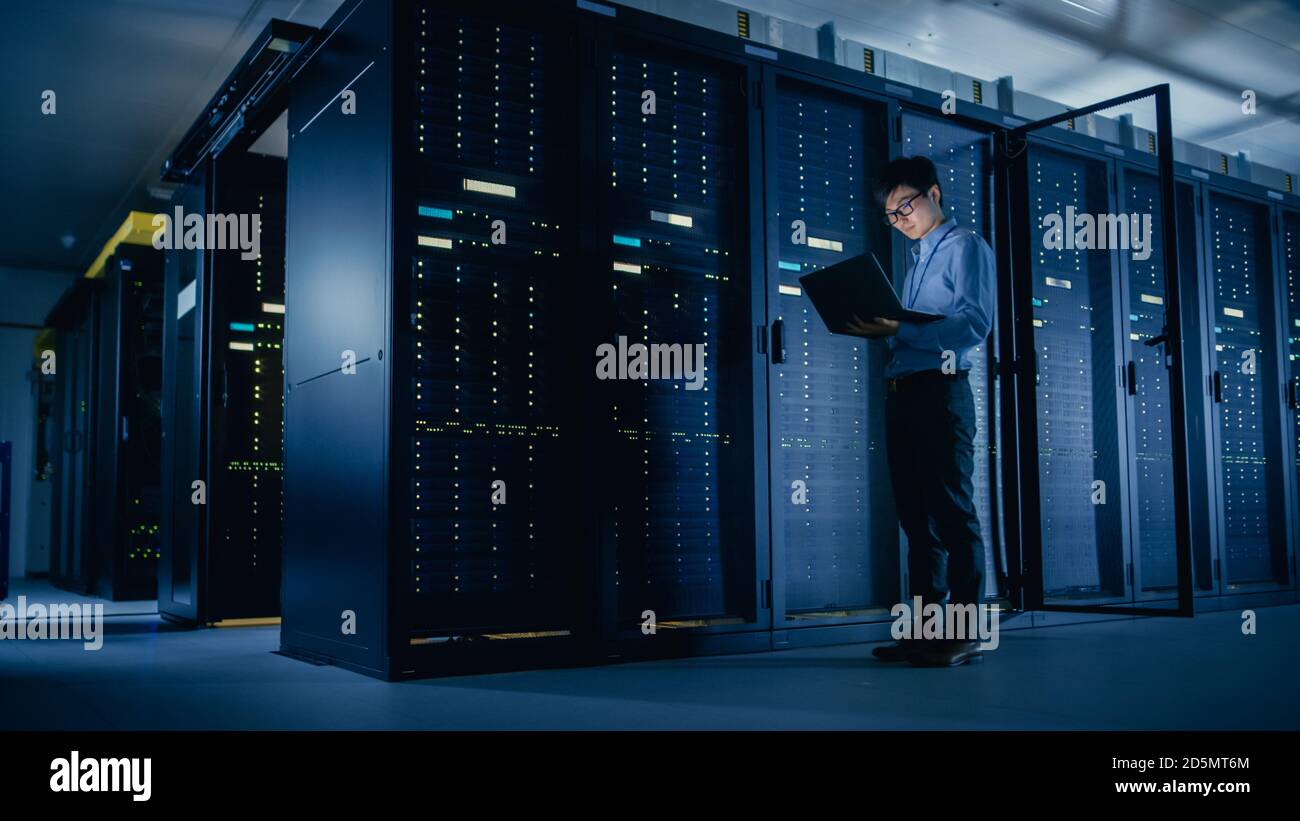 In Data Center: Male IT Technician Running Maintenance Programme on a ...