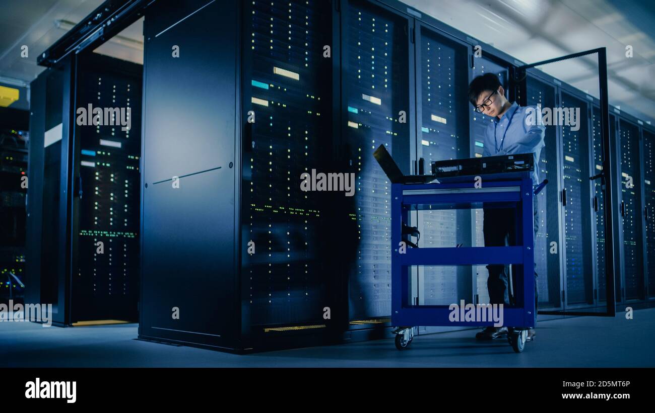 In Data Center: Male IT Technician Running Maintenance Programme on a ...