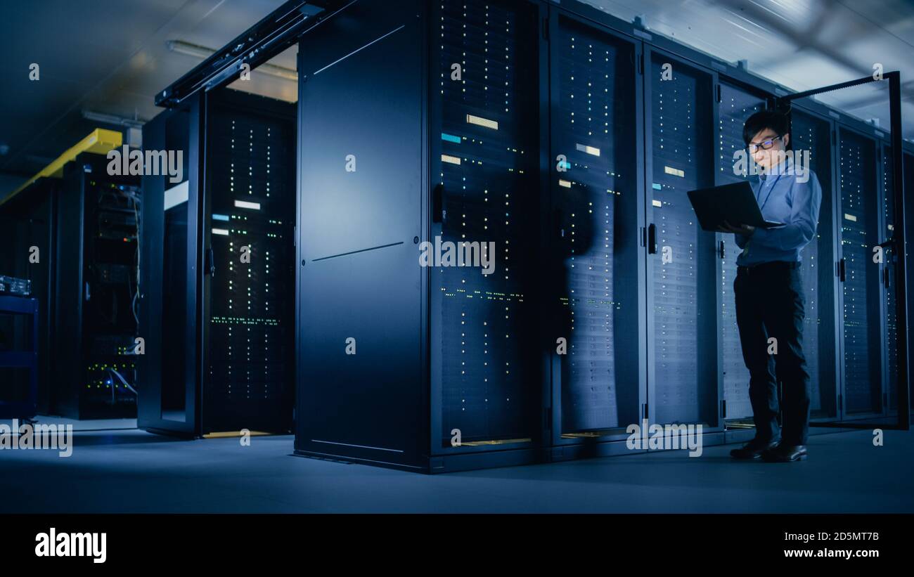 In Data Center: Male IT Technician Running Maintenance Programme on a ...