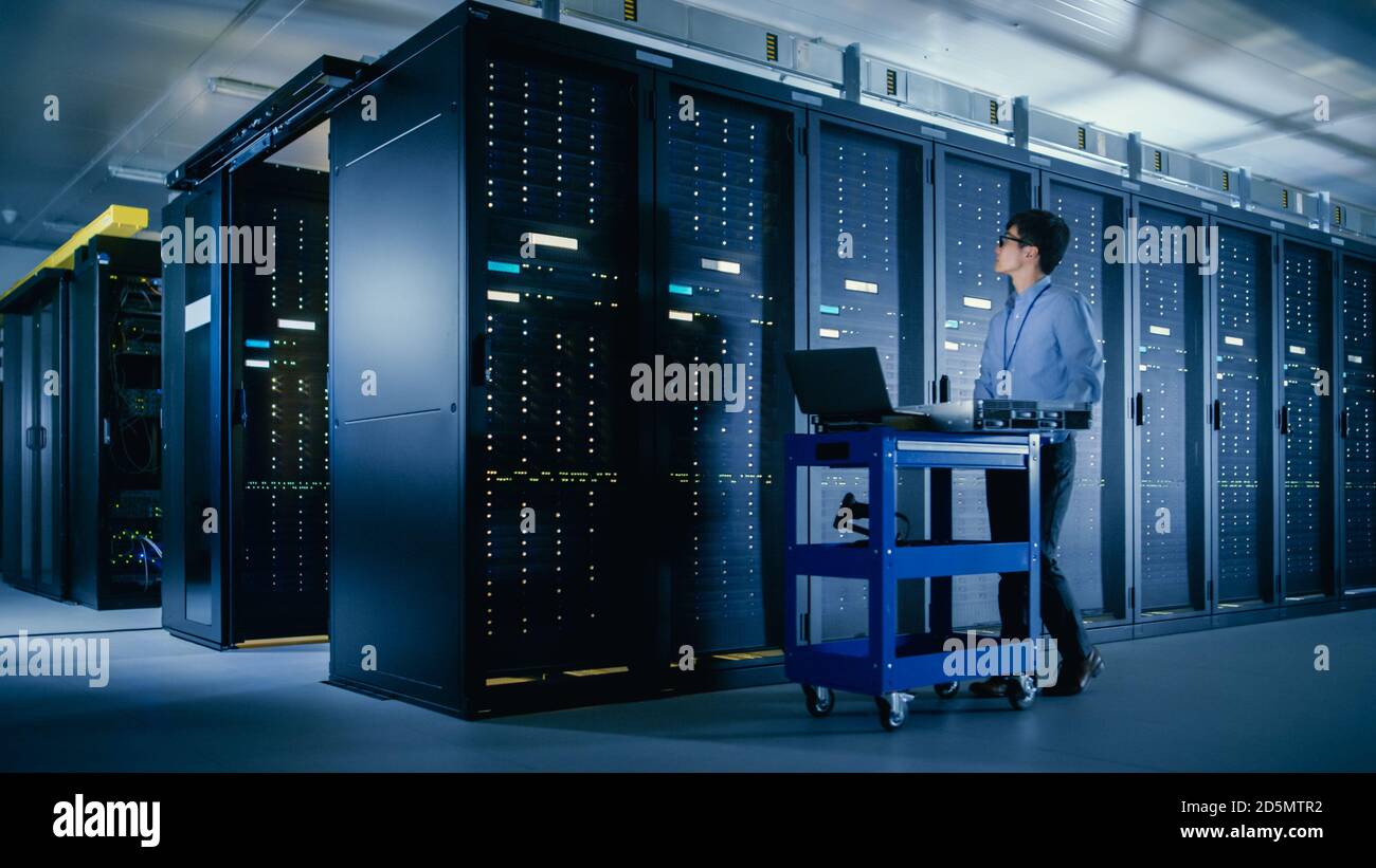 In the Modern Data Center: IT Engineer Doing Maintenance and ...