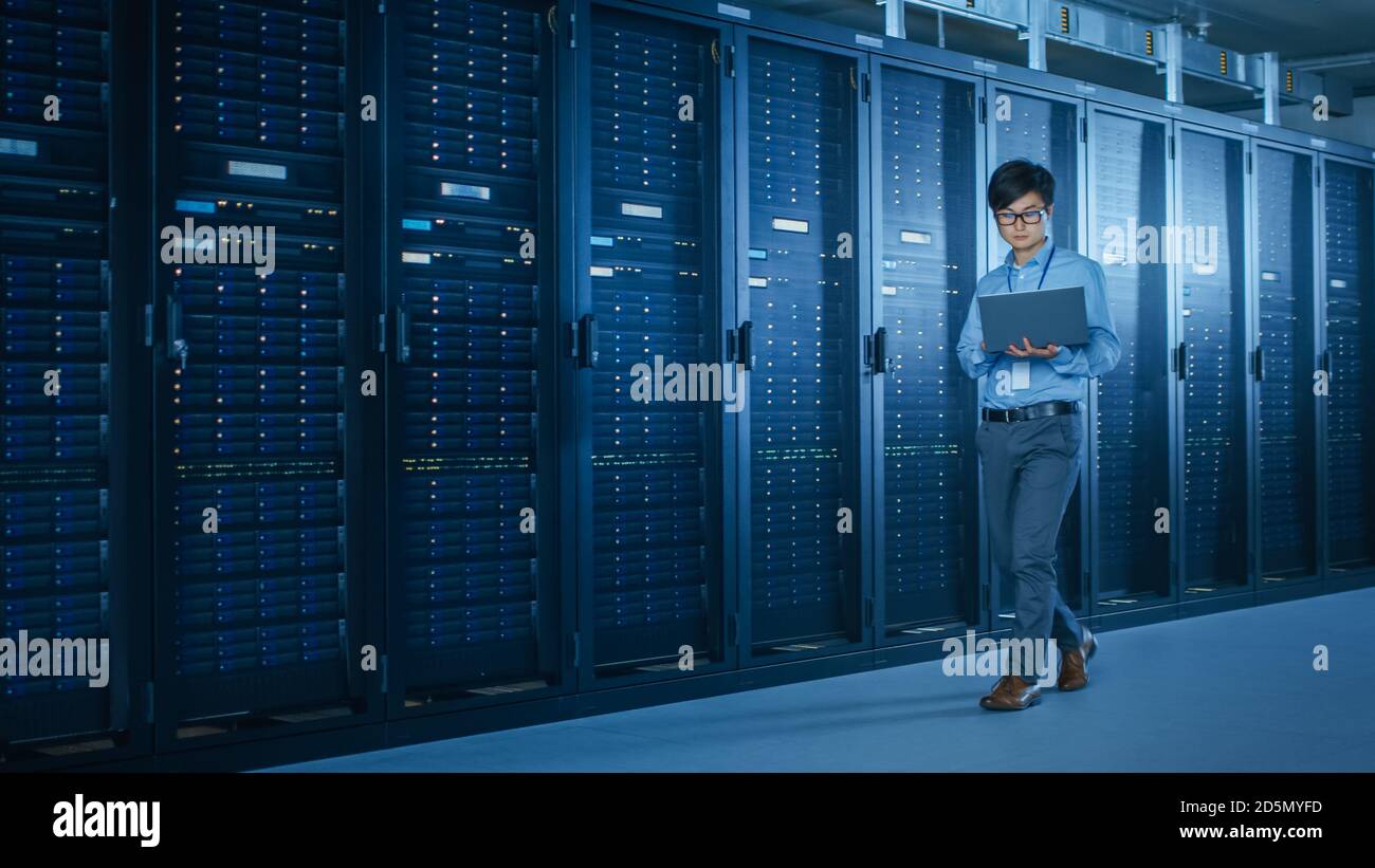 In the Modern Data Center: IT Engineer Working with Server Racks, Uses ...