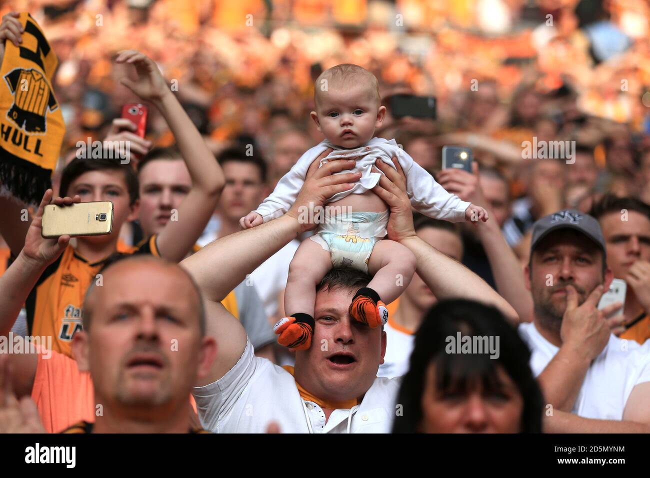 A Hull City fan holds aloft a baby in the stands at Wembley Stadium ...