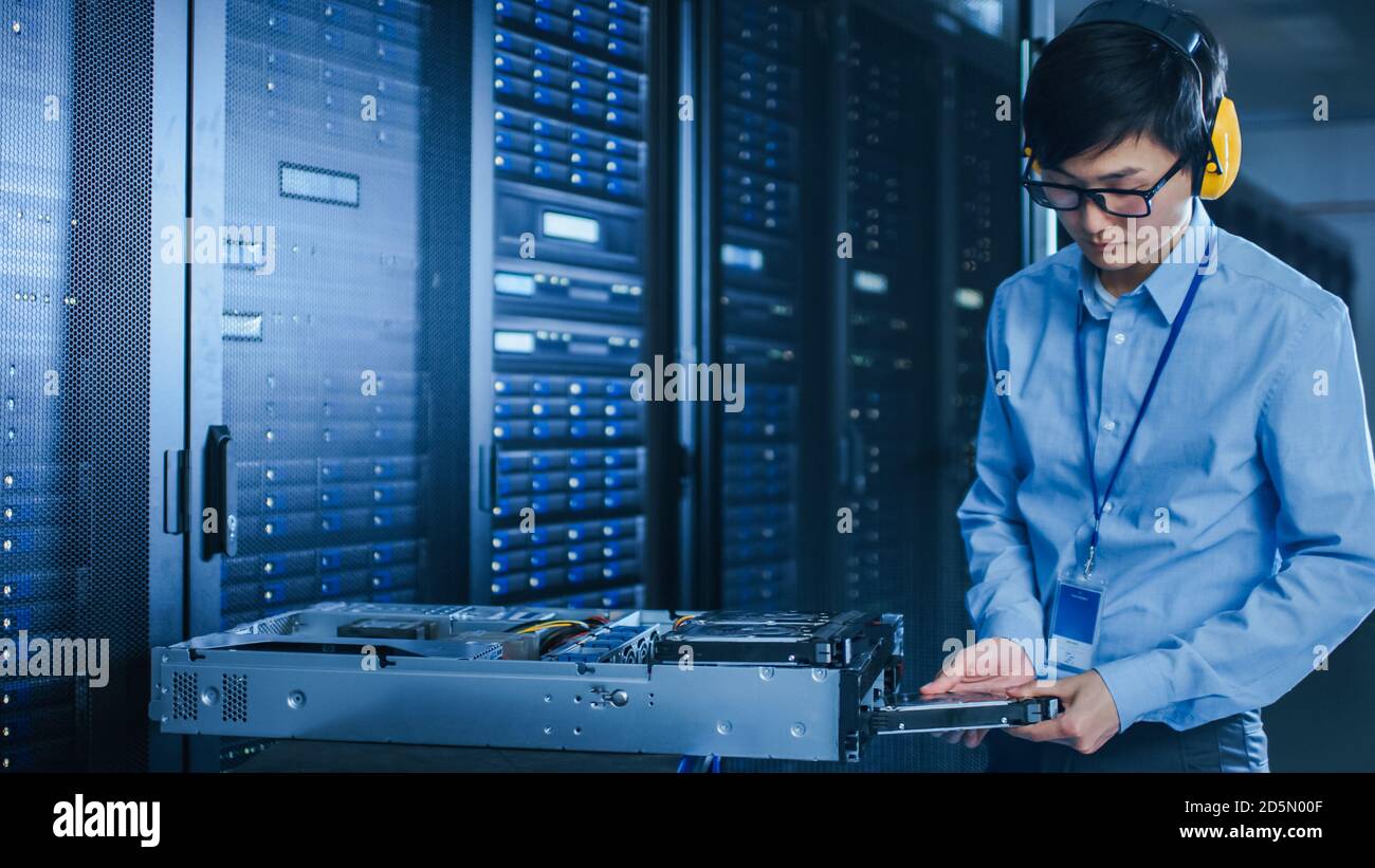 In the Modern Data Center: IT Technician Working with Server Racks, on ...