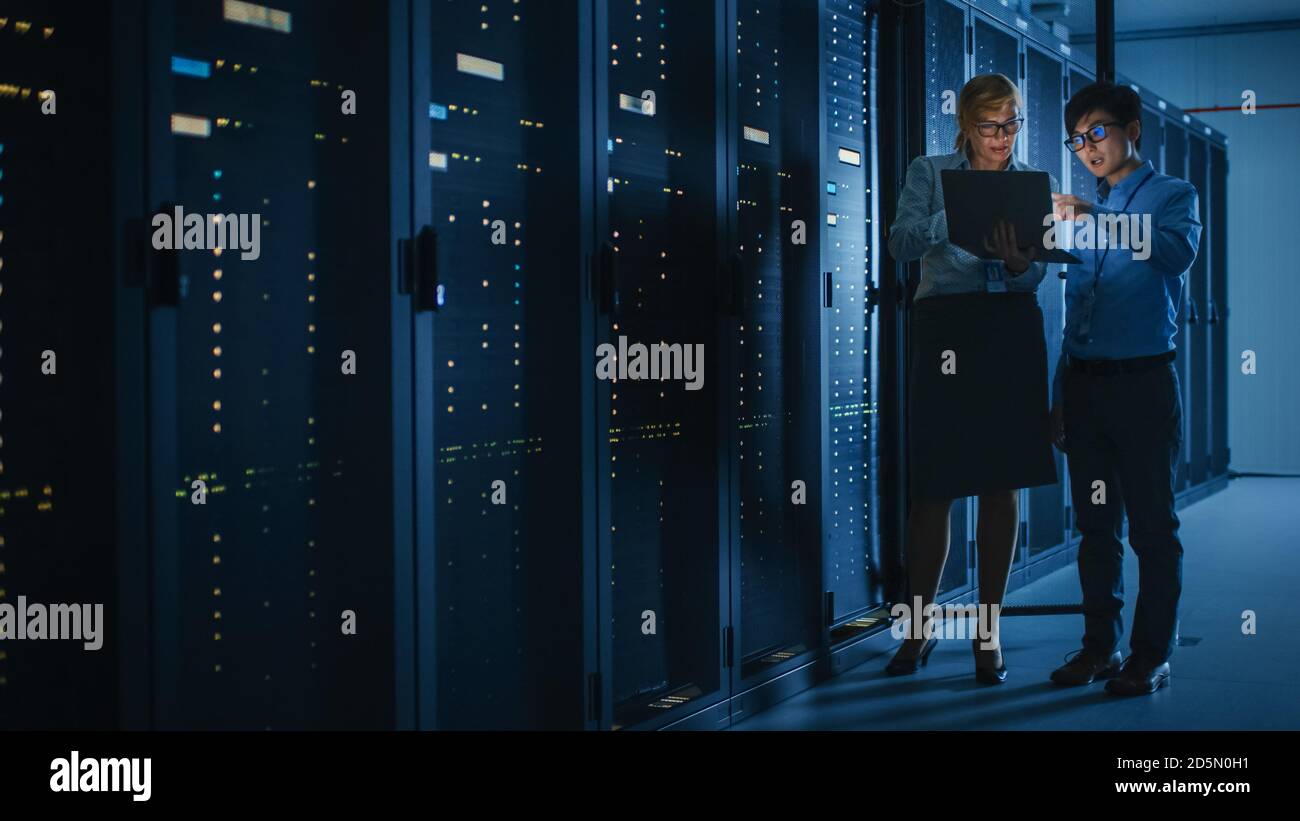 In the Modern Data Center: Engineer and IT Specialist Work with Server ...