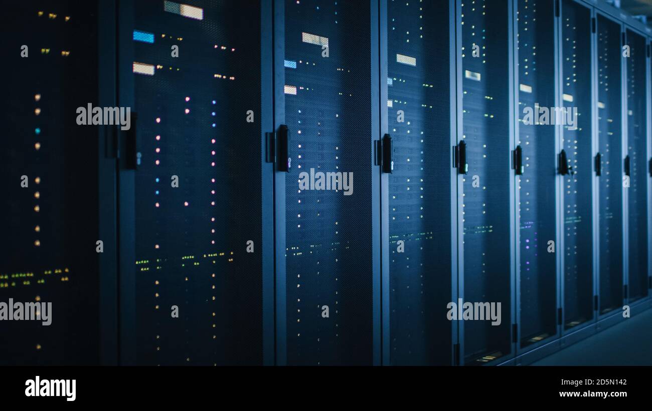 Shot of Dark Data Center With Multiple Rows of Fully Operational Server Racks. Modern ...