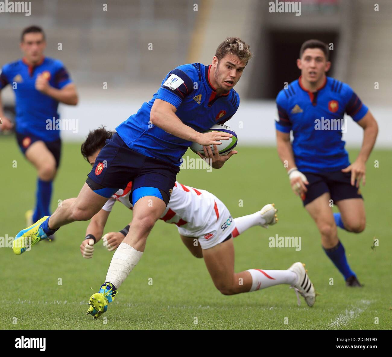 France's Damian Penaud drives through a tackle to score his sides ...