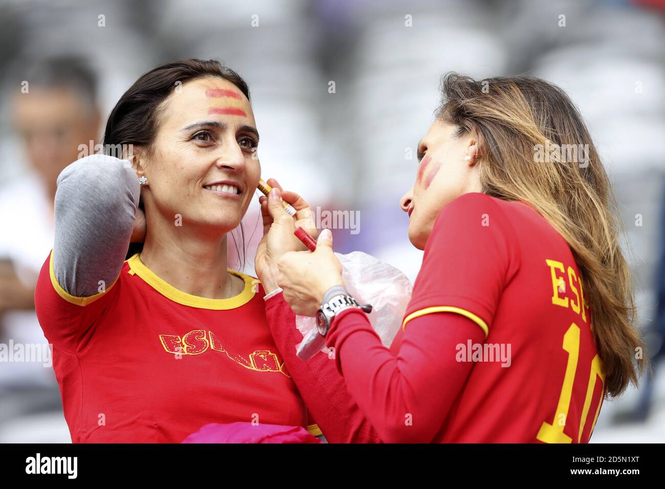 Spain fans apply face paint in the stands at the Stadium de Toulouse ...