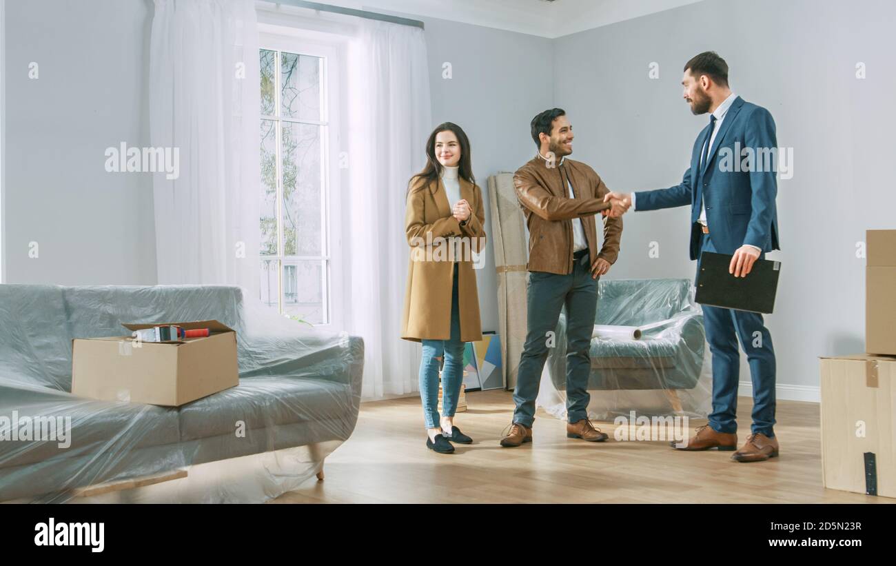 Professional Real Estate Agent Shows Bright New Apartment to Young ...