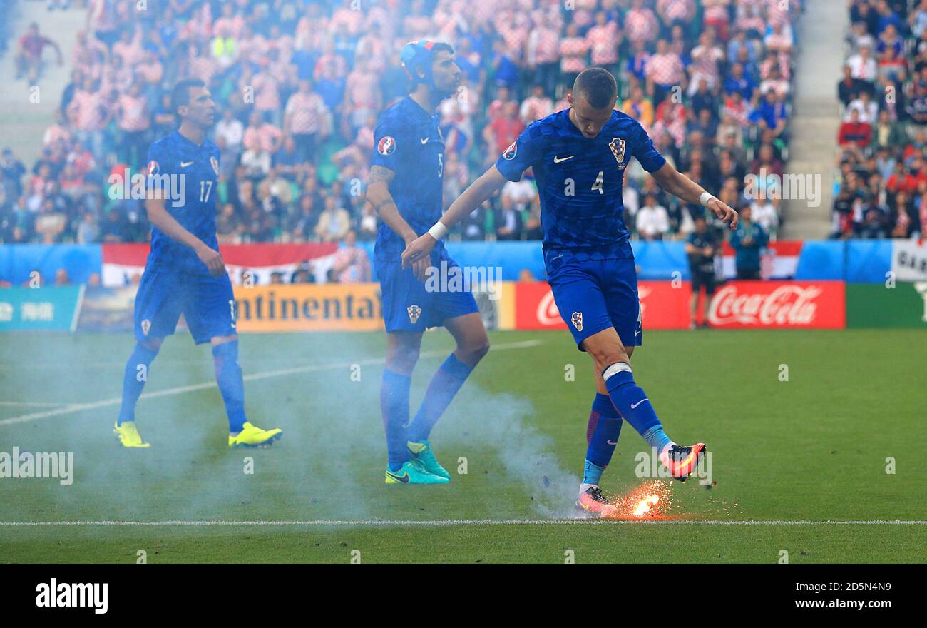 Croatia's Ivan Perisic tries to extinguish a flare that was thrown onto ...