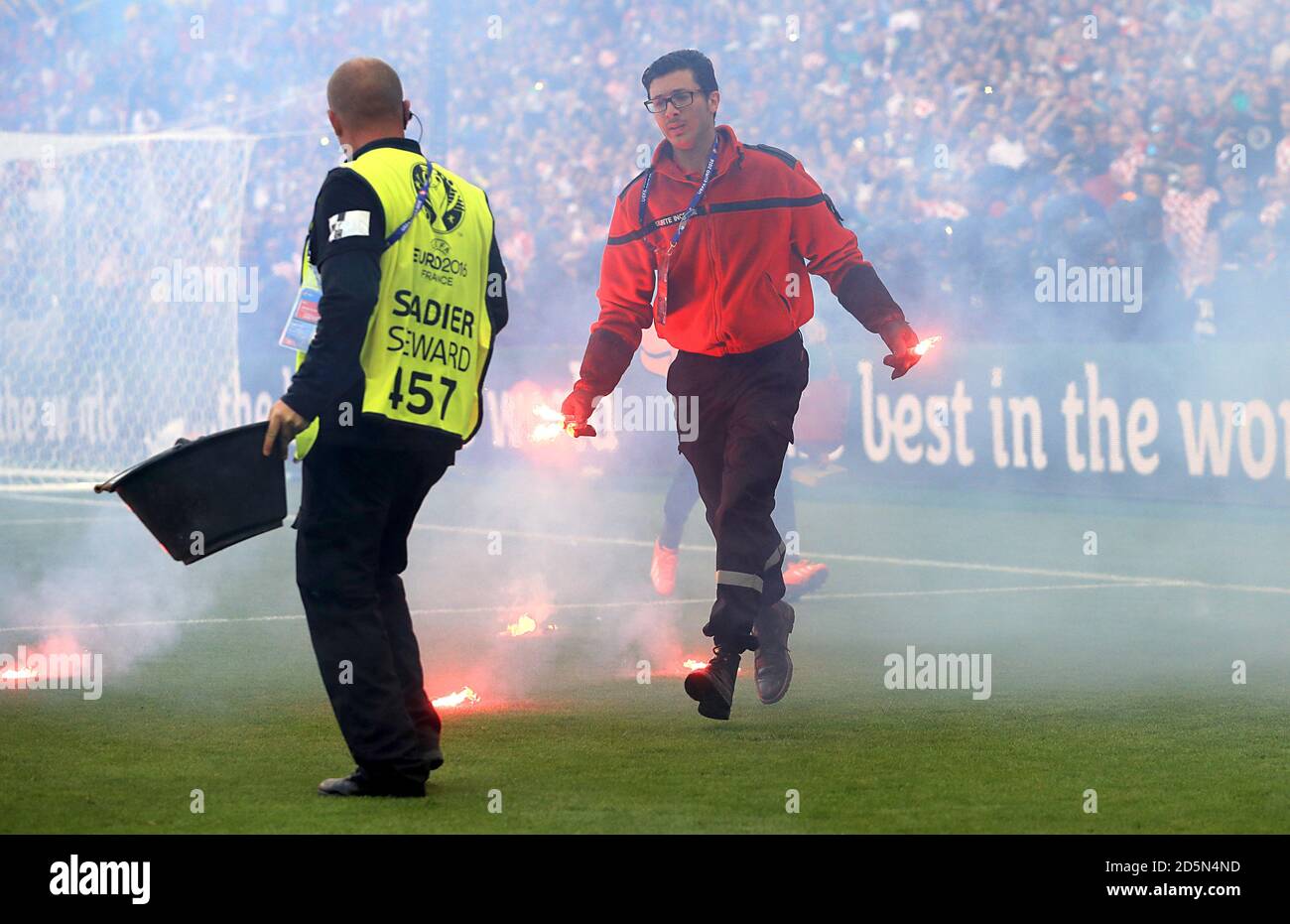 Fire Marshalls extinguish a flare after it was thrown onto the pitch ...