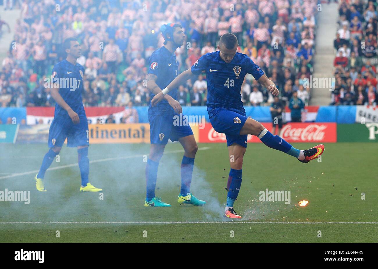 Croatia's Ivan Perisic tries to extinguish a flare that was thrown onto ...