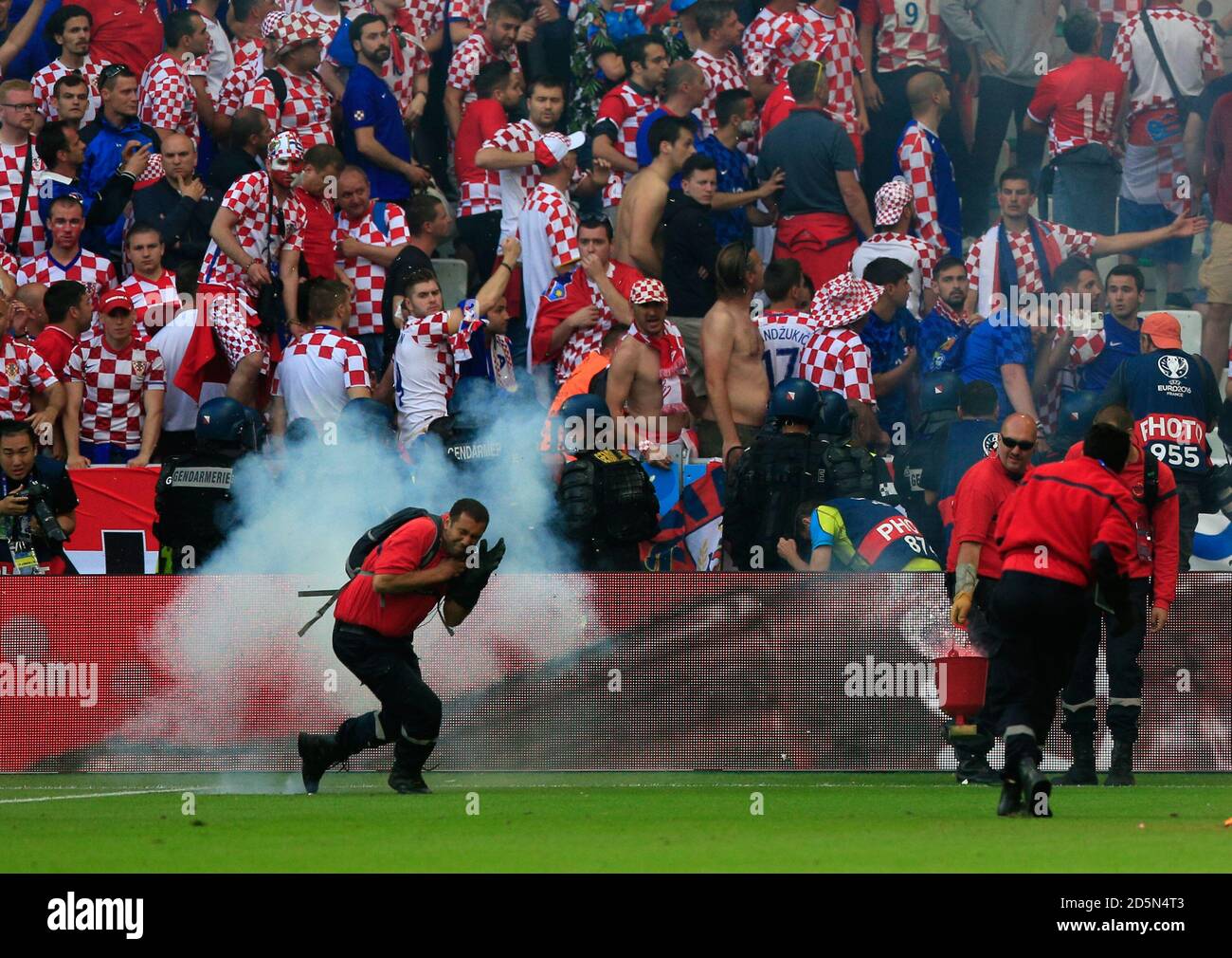 An emergency worker turns away from a thunder flash explosion in front ...