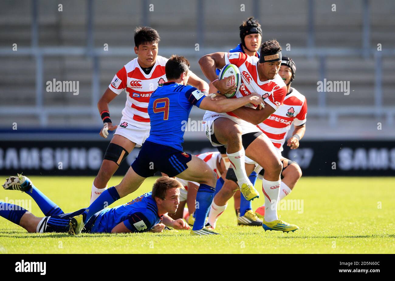 France's Baptiste Couilloud (left) tackles Japan's Ataata Moeakiola ...