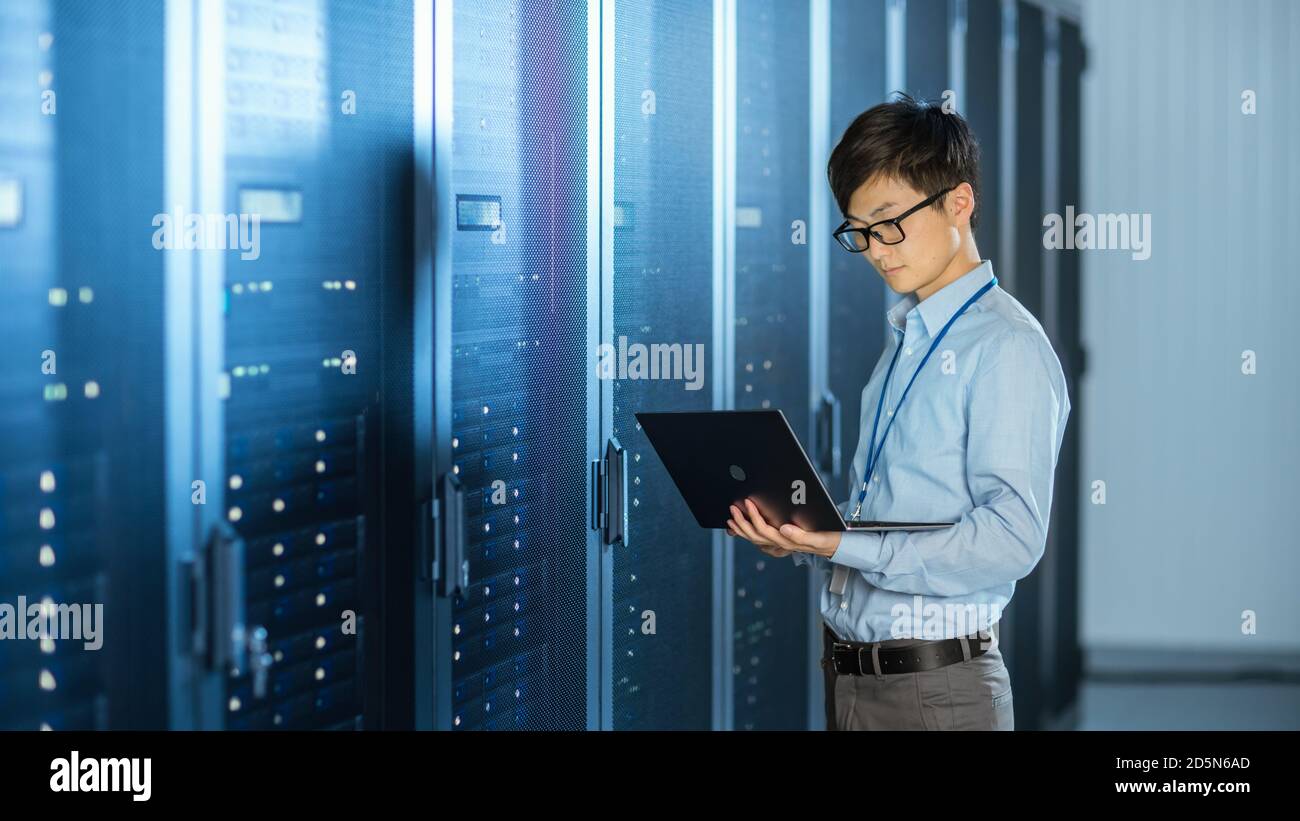 In the Modern Data Center: IT Engineer Standing Beside Server Rack ...