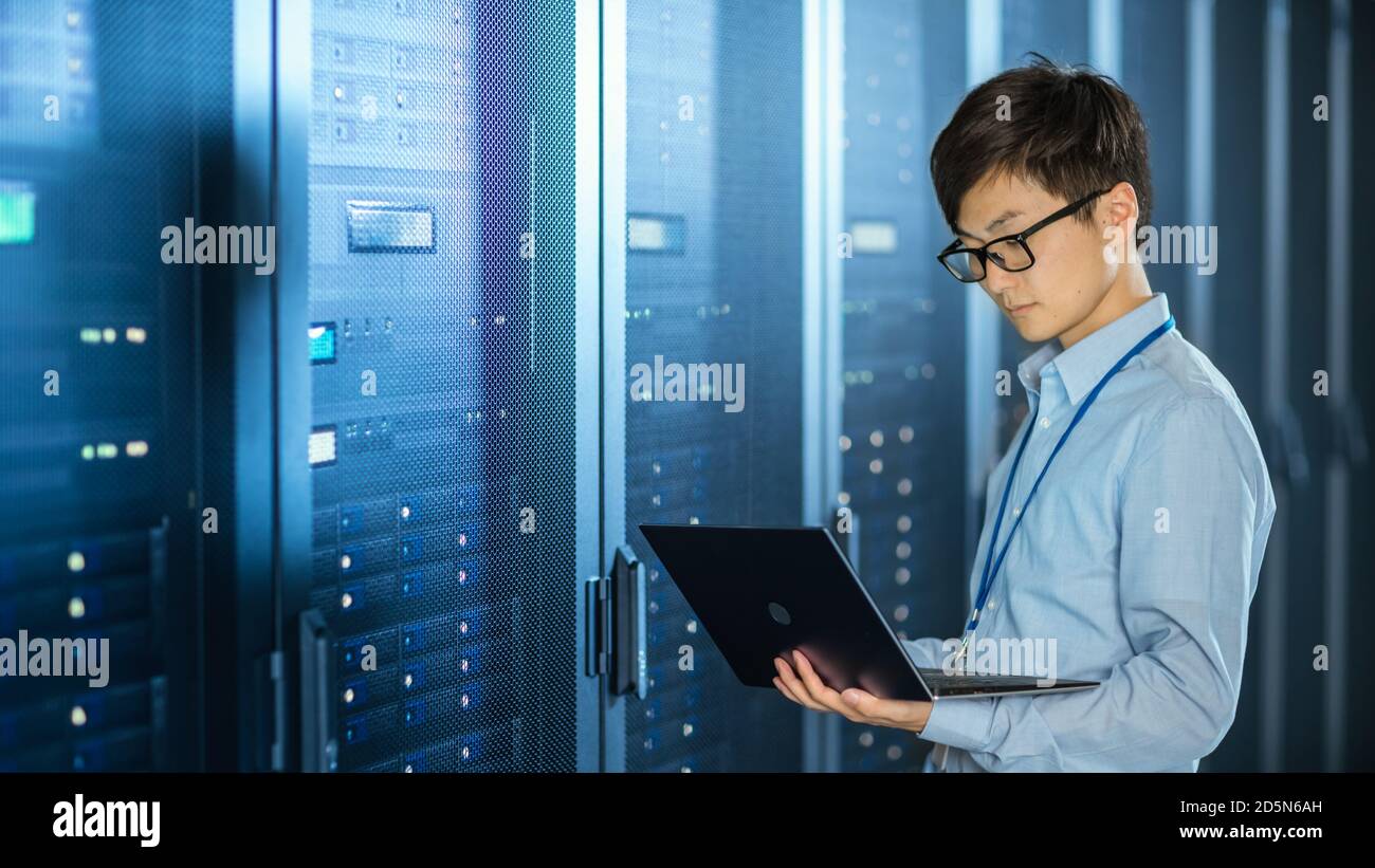 In the Modern Data Center: IT Engineer Standing Beside Server Rack ...