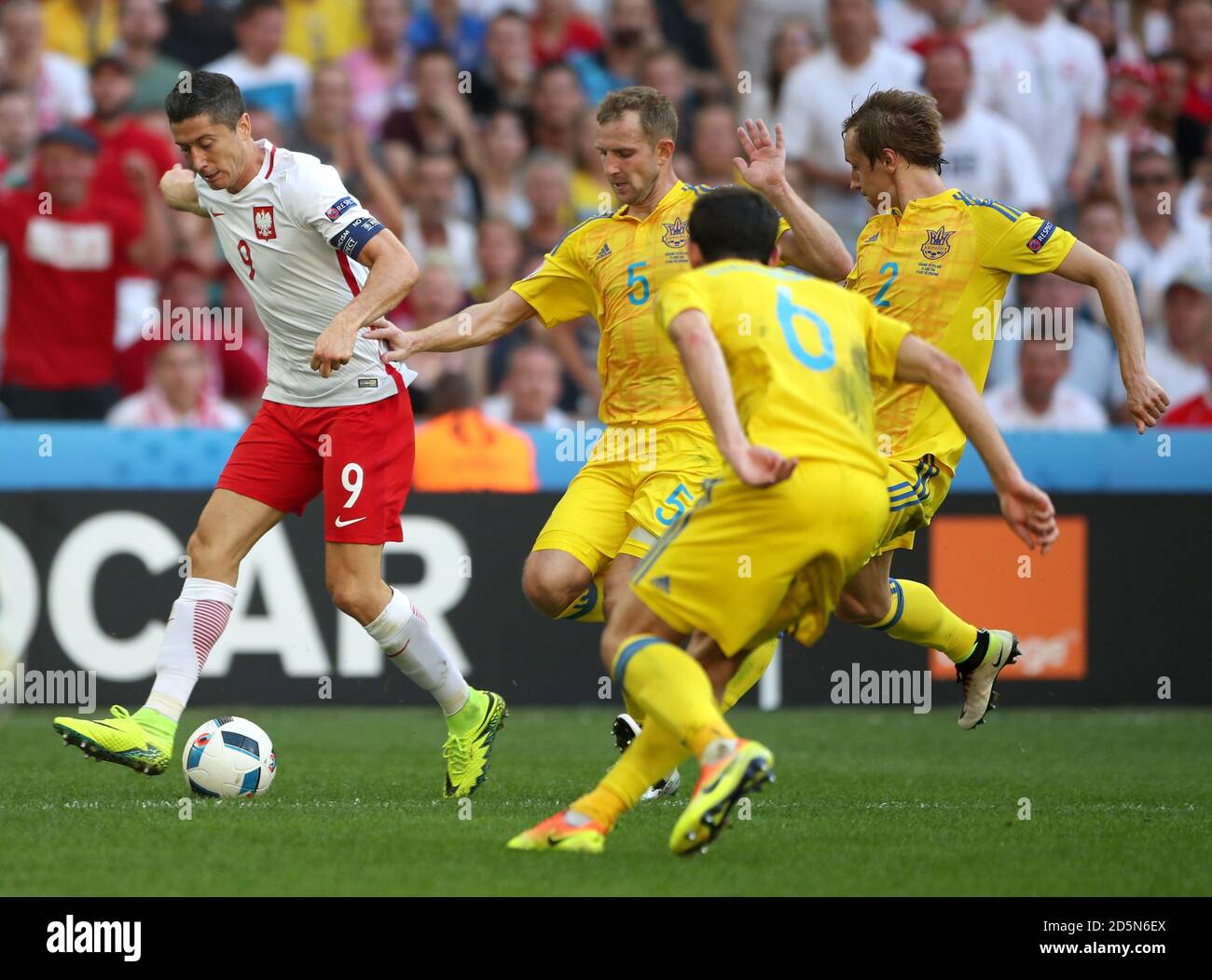 Poland's Robert Lewandowski (left) breaks through the Ukraine defence ...