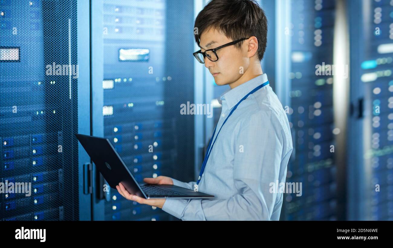 In the Modern Data Center: IT Engineer Standing Beside Server Rack ...