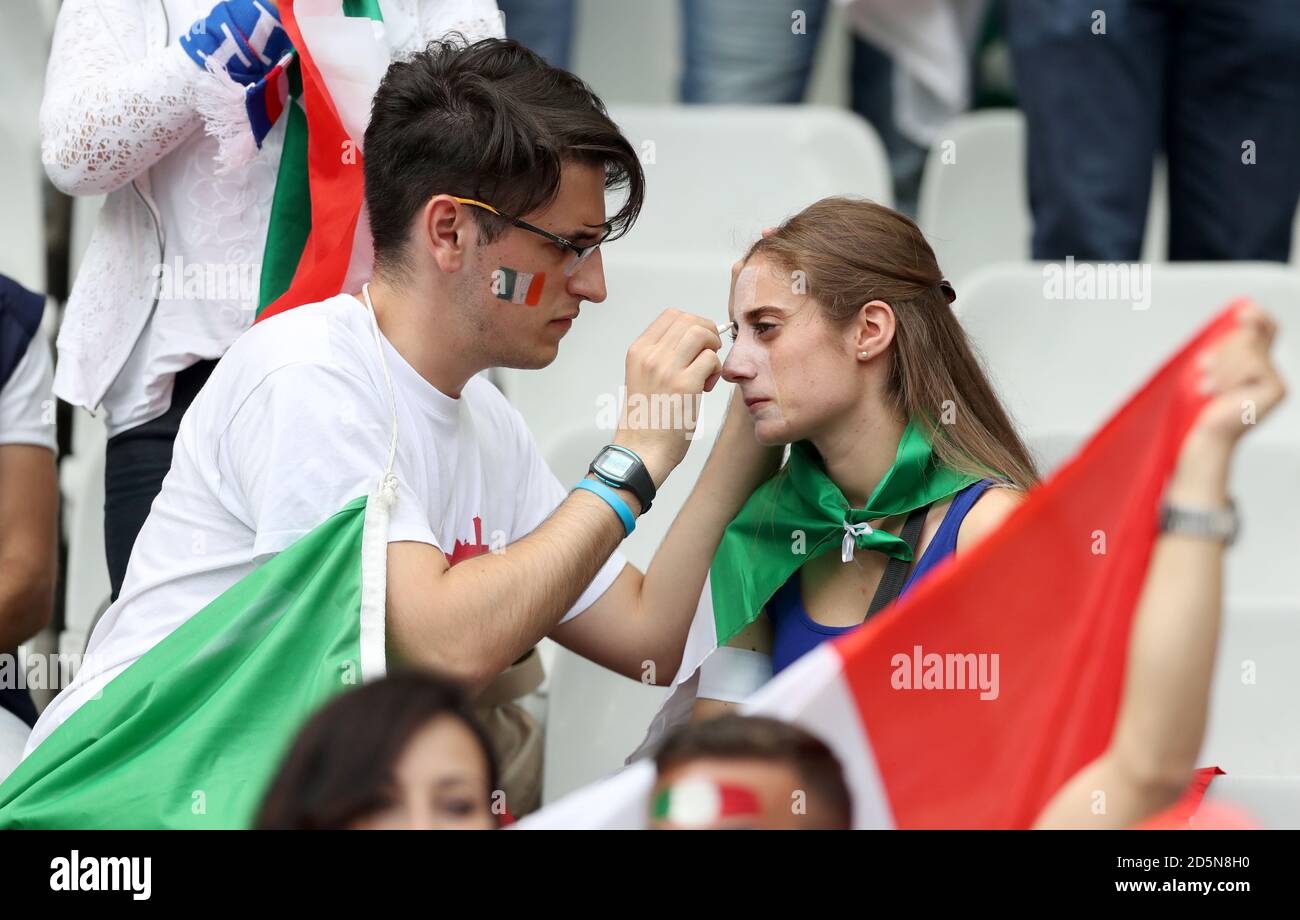 Italy fans paint their faces in the stands before the match Stock Photo ...