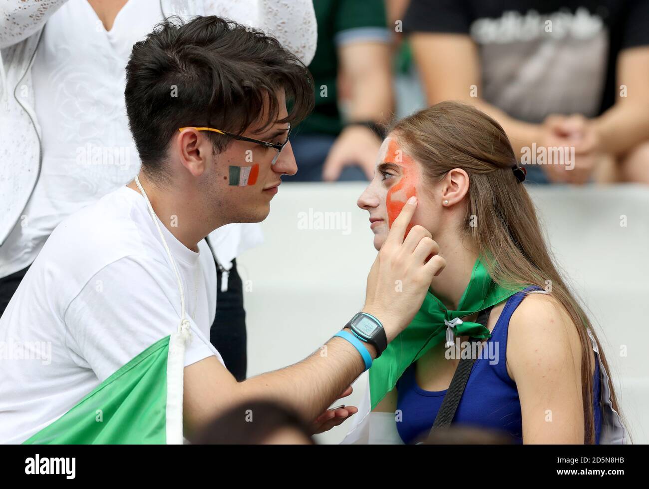 Italy fans paint their faces in the stands before the match Stock Photo ...