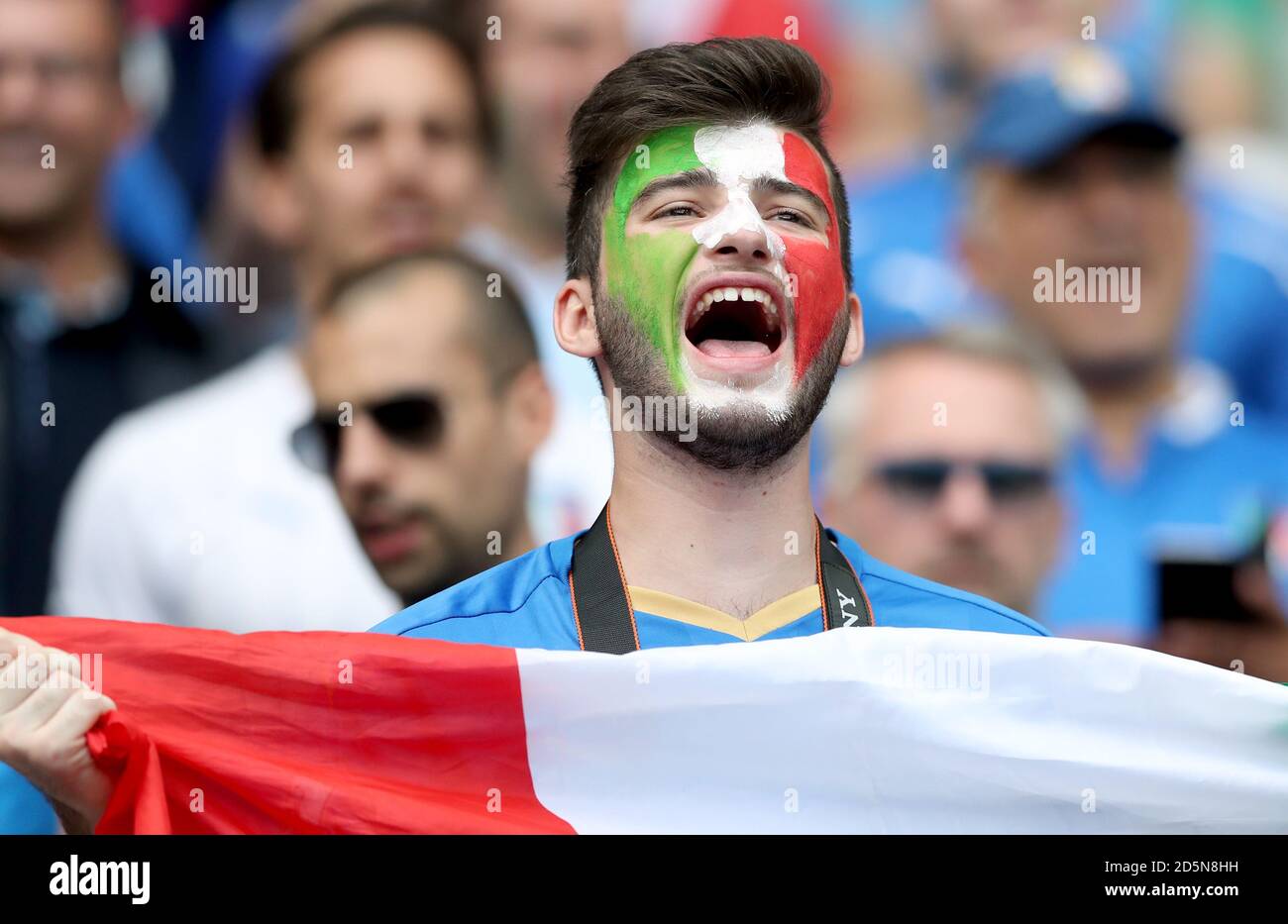 A Italy fan wearing face paint cheers on his side in the stands Stock ...