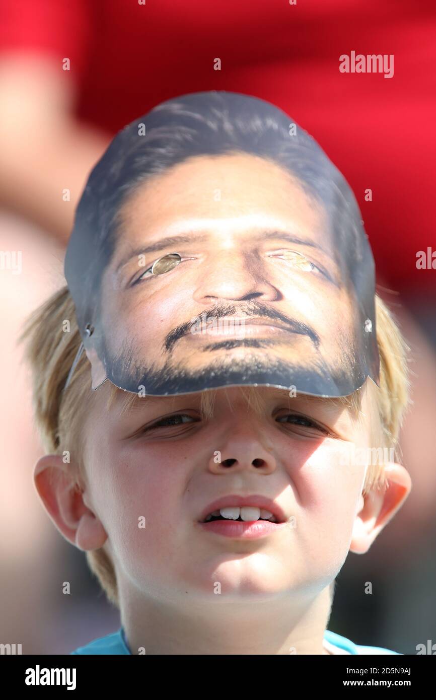 A young Surrey fan in the stands wearing a Kumar Sangakkara mask Stock ...