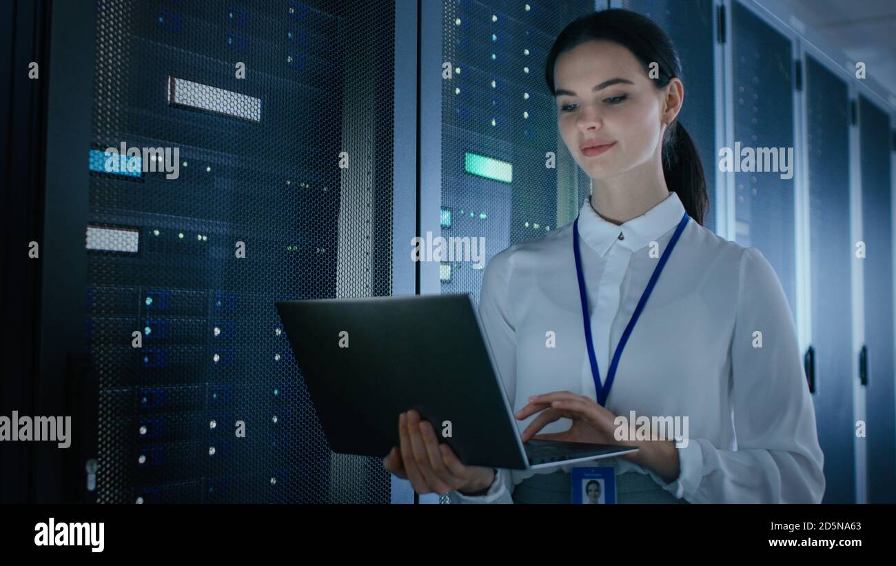 Confident and Beautiful Female IT Engineer is Working on Laptop in Data ...