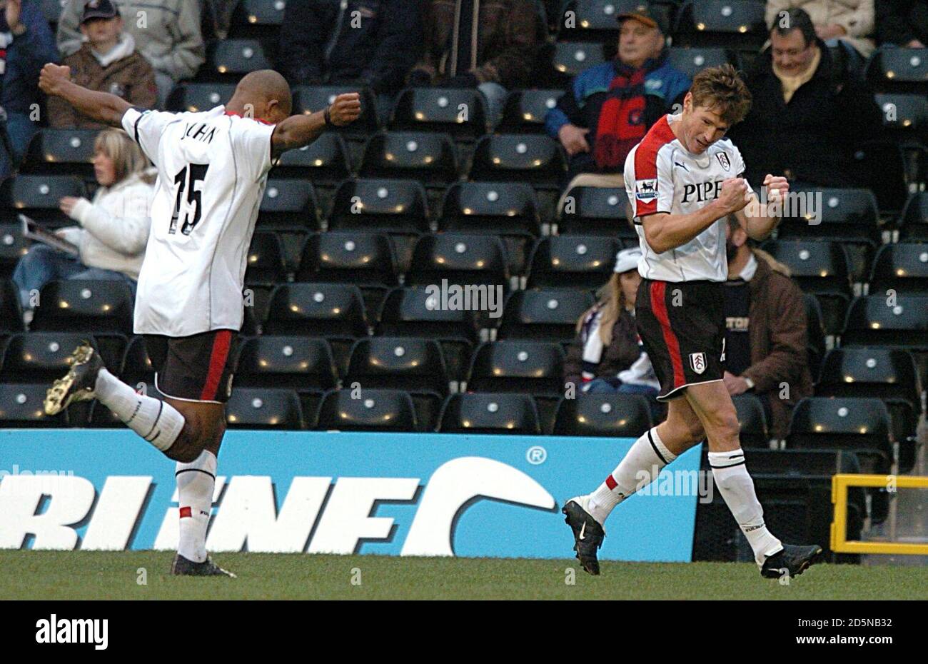 Fulham's Collins John runs to celebrate with goalscorer Brian McBride ...