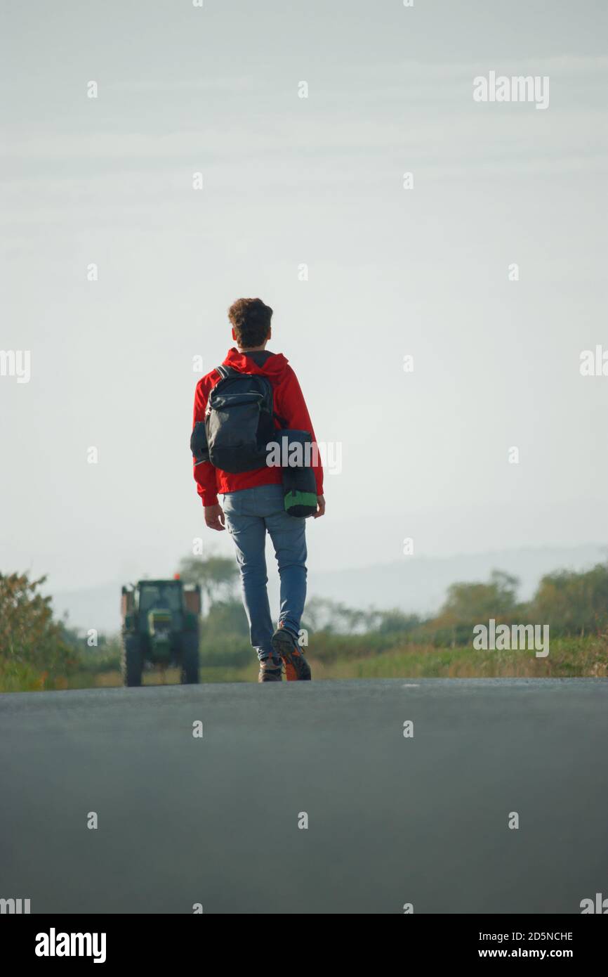 Backpacker walking on the road Stock Photo - Alamy