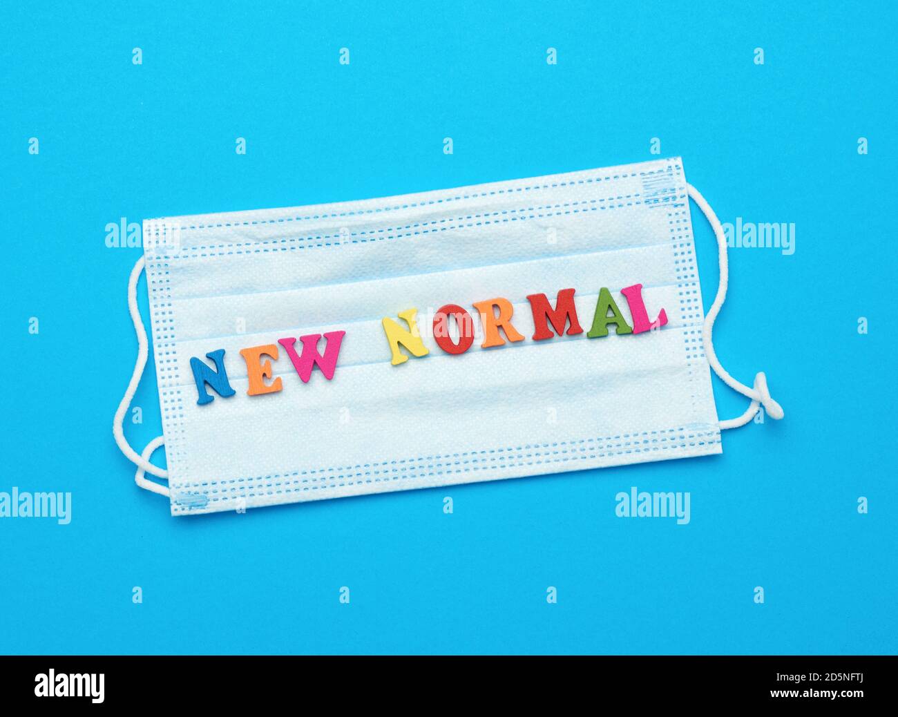 disposable medical face mask and lettering new normal on blue ...