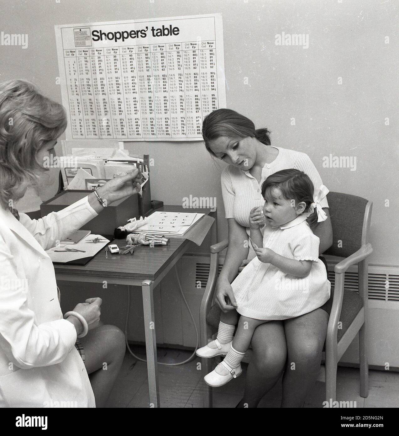 1971, historical, a mother with her infant child seeing a female doctor ...