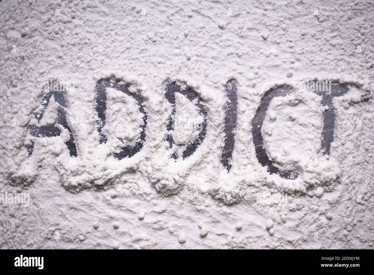 Addict text written in white flour powder. Concepts of addiction and ...