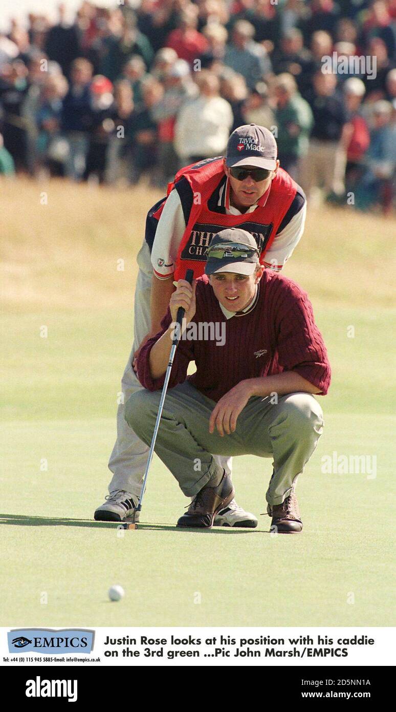 Justin Rose looks at his position with his caddie on the 3rd green ...