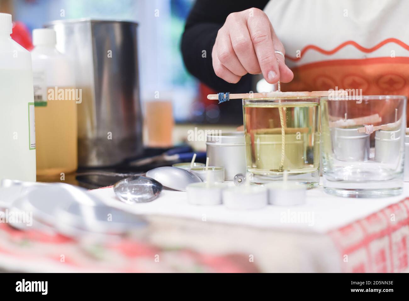 Making candles at home and adding a wick to liquid candle wax Stock ...