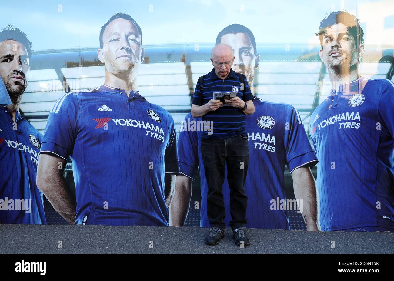 A Chelsea fan reads the match day programme outside the ground before ...
