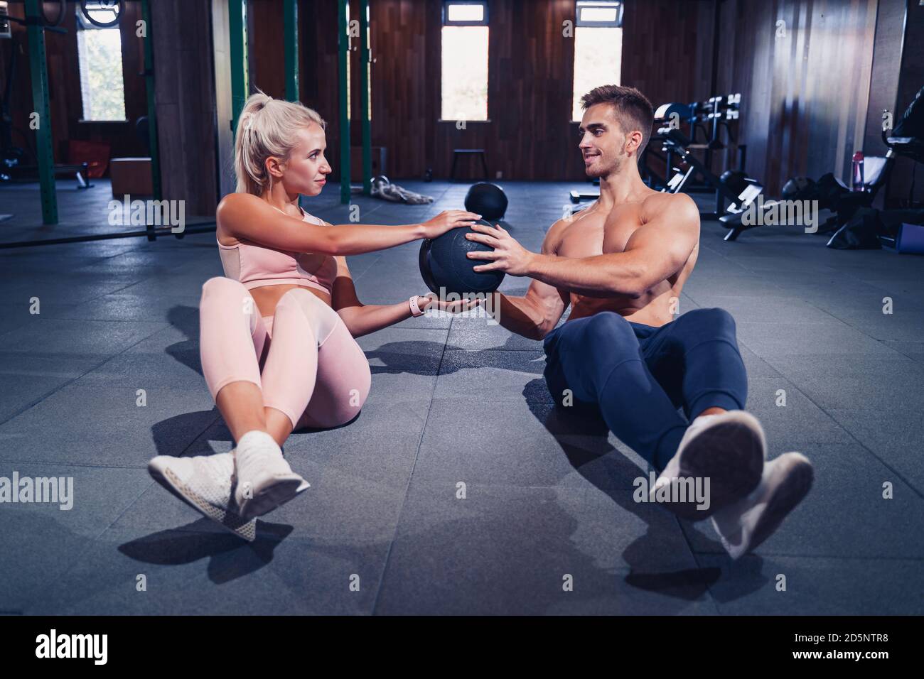 Fit couple doing abdominal ball exercise at gym Stock Photo - Alamy