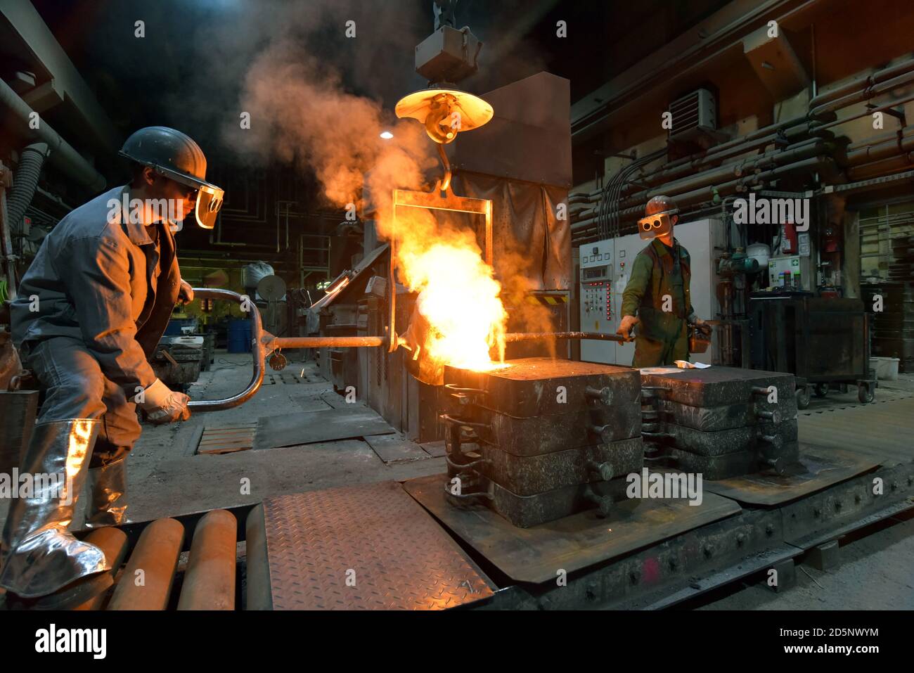 workers in a foundry casting a metal workpiece - safety at work and ...