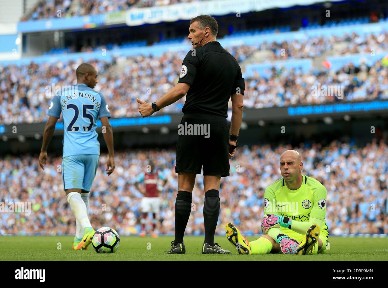 Manchester City goalkeeper Willy Caballero sits in pain with a arm ...