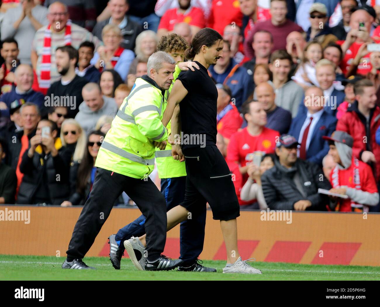 A pitch invader is removed by stewards Stock Photo - Alamy