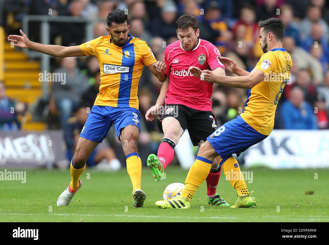 Mansfield Town's Malvind Benning (left) and Chris Clements challenge ...