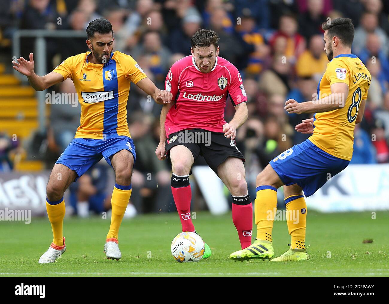 Mansfield Town's Malvind Benning (left) and Chris Clements challenge ...