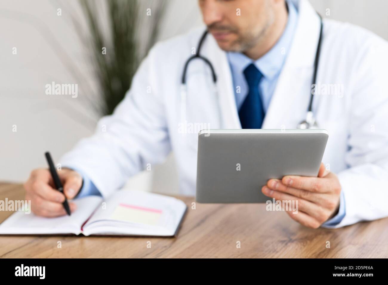 Close up of medical practitioner filling in paperwork Stock Photo - Alamy
