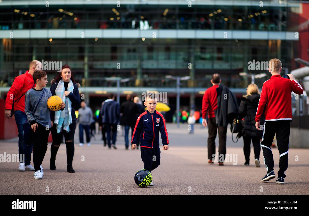 A young Arsenal fan kicks a football outside of The Emirates Stock ...