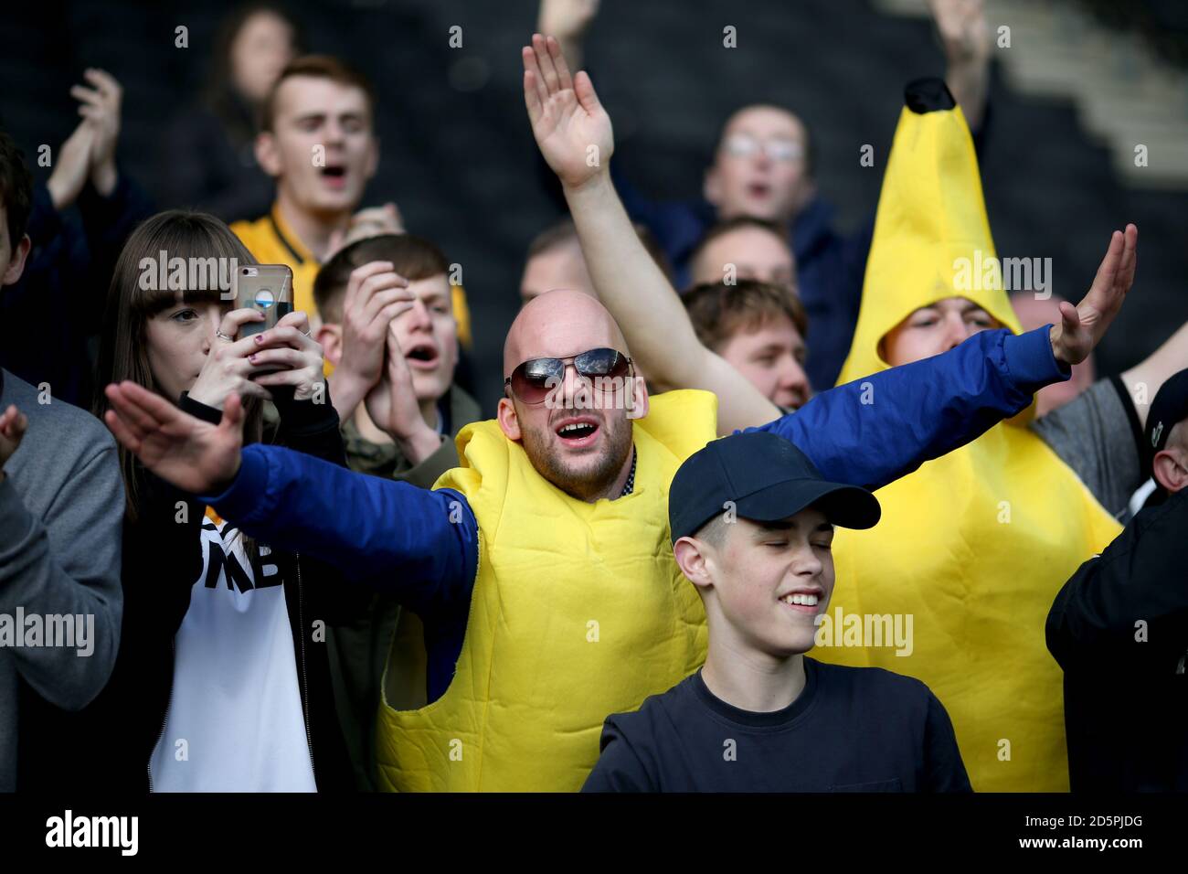 Fans dressed as bananas cheer on their side in the stands Stock Photo ...