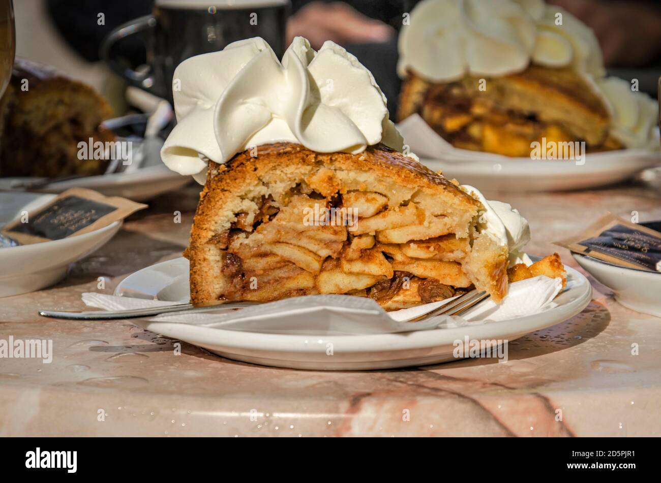 Piece of apple pie topped with whipped creamon a fake marble plastic ...