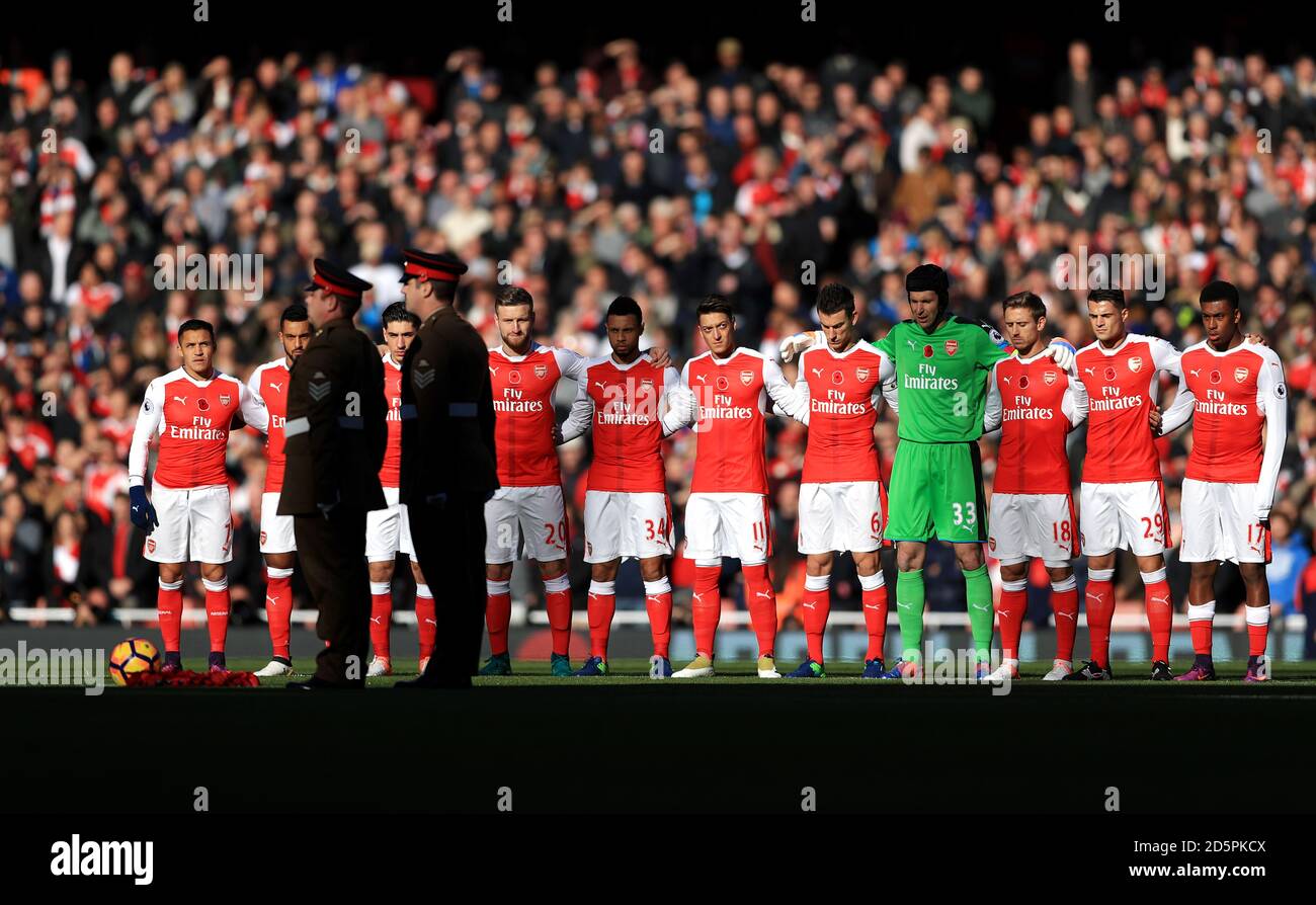Arsenal players stand arm-in-arm before the game to remember the ...
