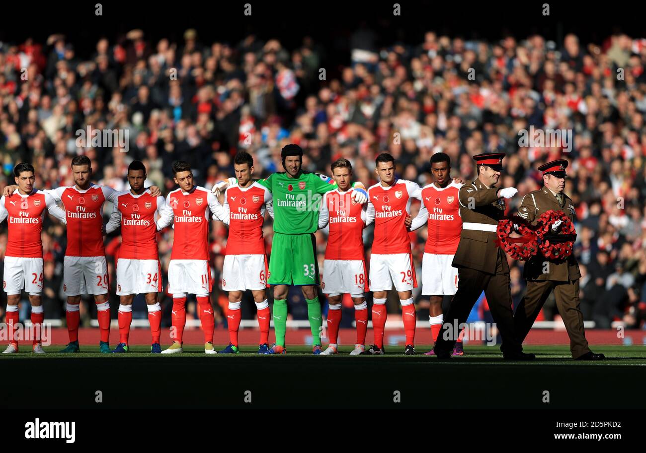 Arsenal players stand arm-in-arm before the game to remember the ...