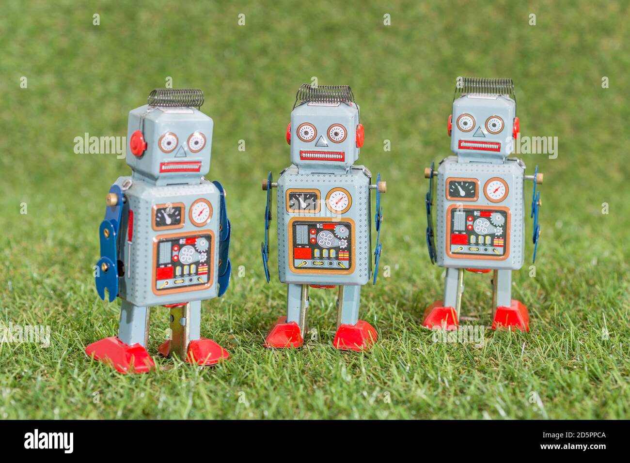 Wind-up clockwork toy robot on fake grass. For troll farm, Russian bots ...