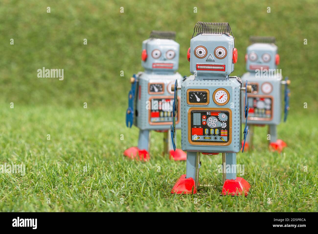 Wind-up clockwork toy robot on fake grass. For troll farm, Russian bots ...